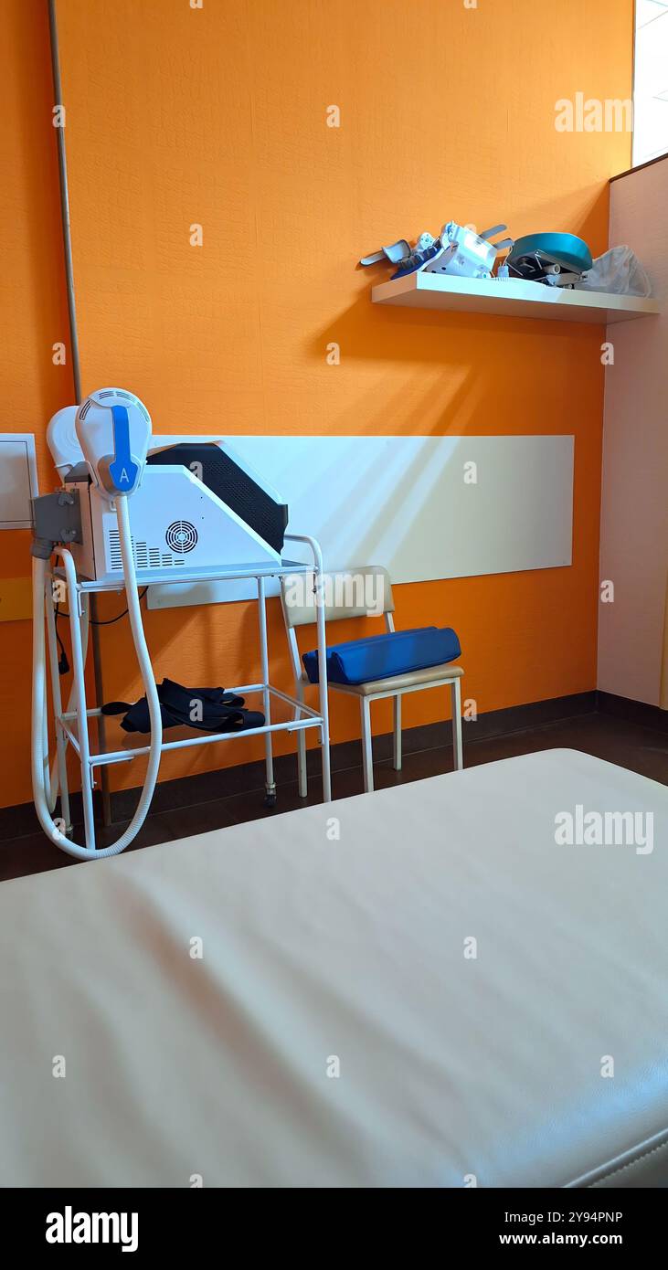 Modern medical examination room with equipment and bright orange walls ...