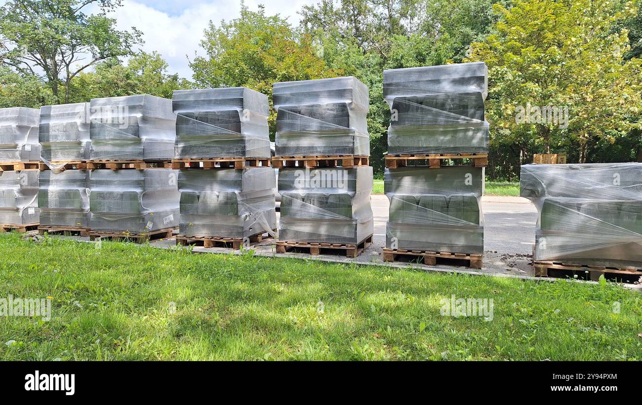 Stacks of palletized goods wrapped in plastic outdoors Stock Photo - Alamy