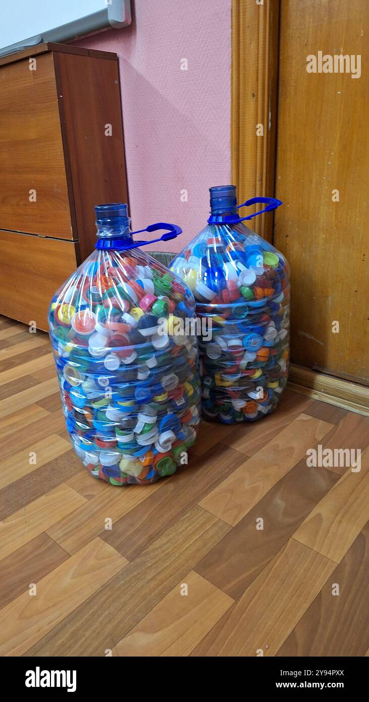 Recycled plastic bottle caps in repurposed water containers for ...