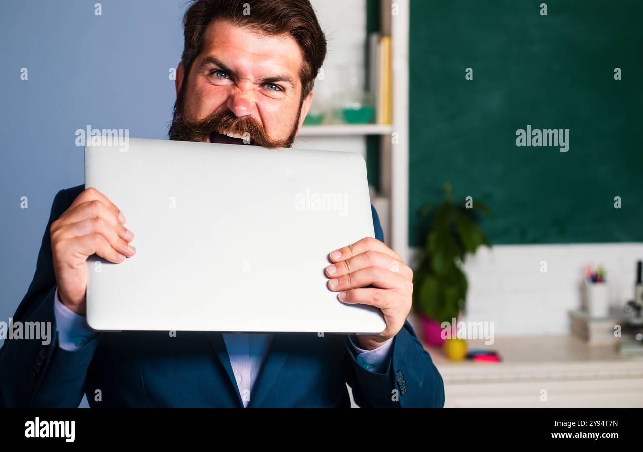 Funny teacher with laptop notebook in classroom at school. Excited ...