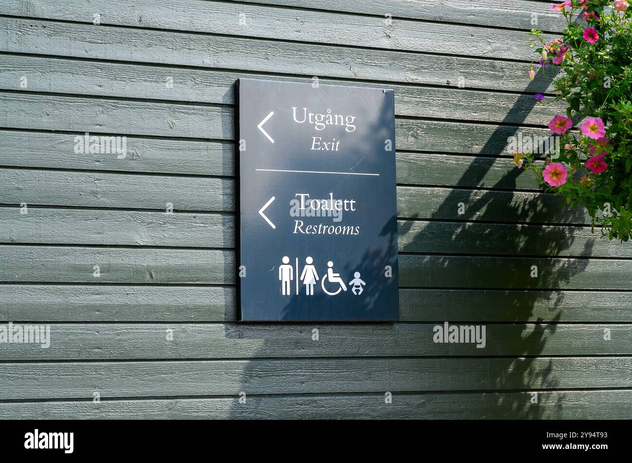 A sign mounted on a wooden wall provides clear directions to restrooms ...