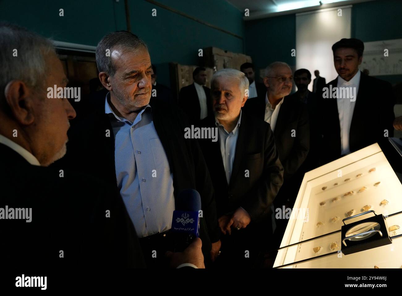 Iranian President Masoud Pezeshkian, second left, looks at ancient clay ...