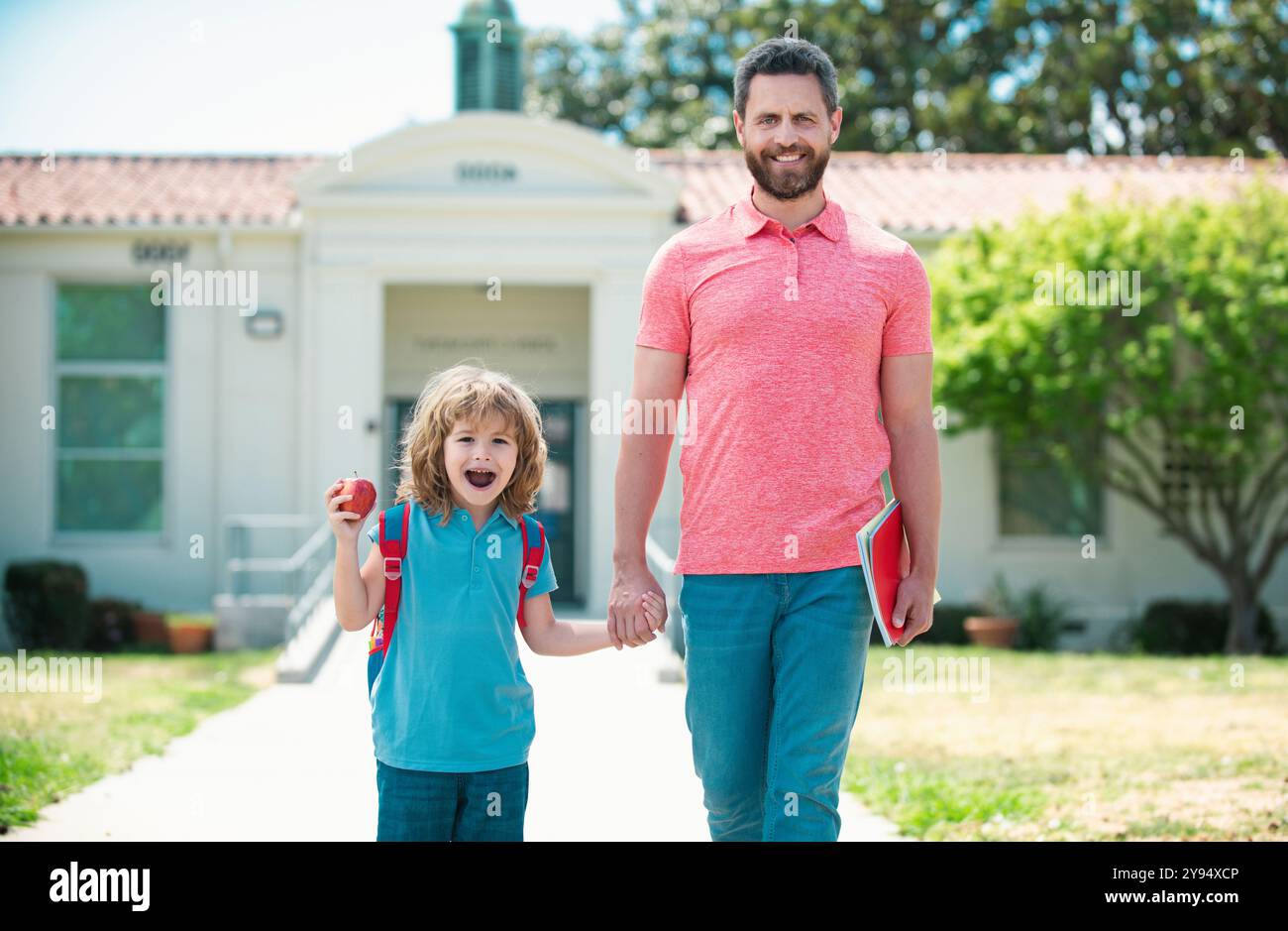 Parent and pupil of primary school go hand in hand. Father and son go ...