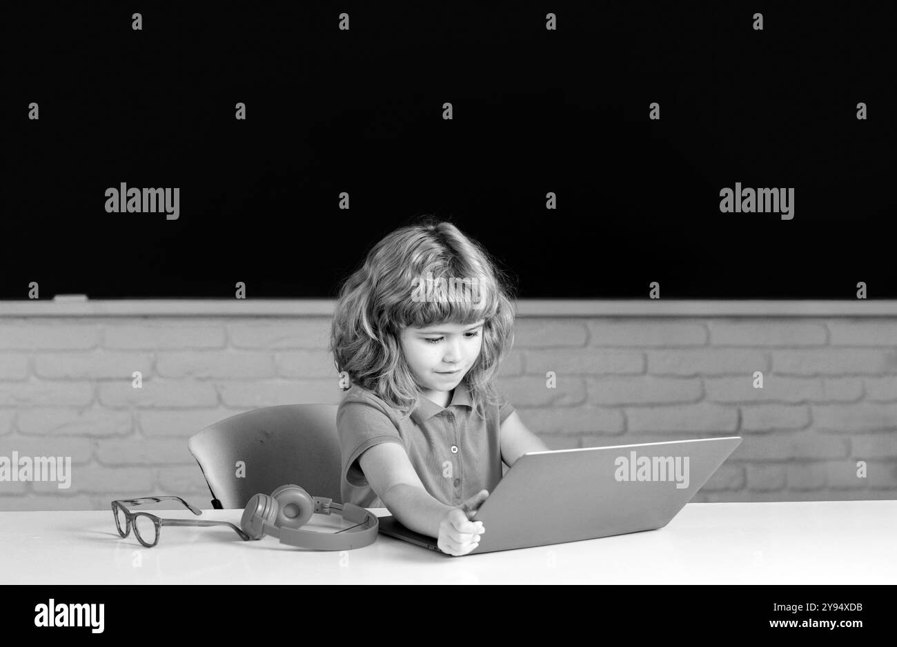 Concentrated school boy studying math during online lesson in classroom ...
