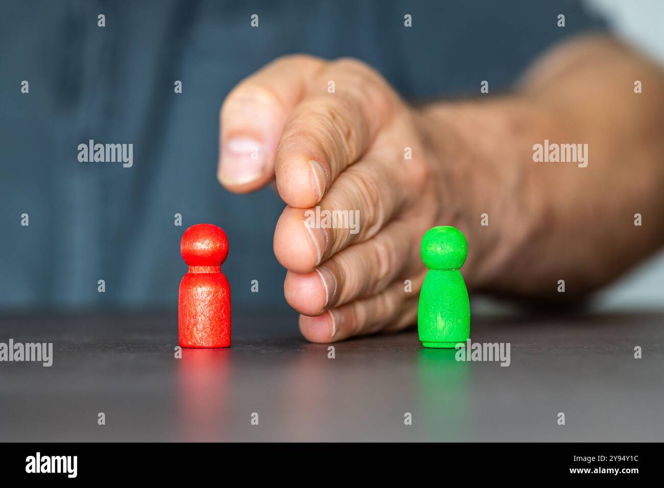 Person holds hand between two wooden figures. Soft skills and conflict ...