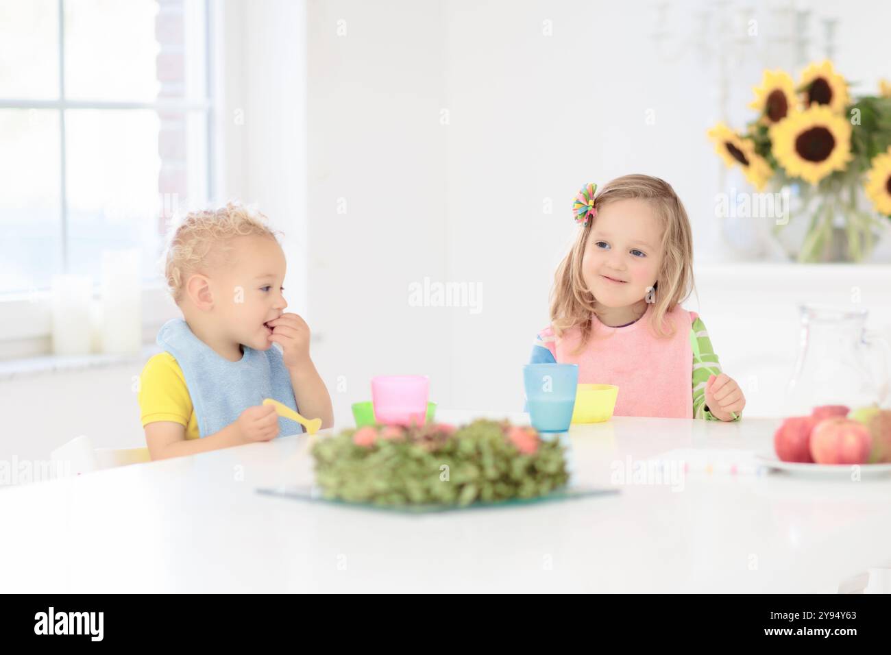 Kids eating breakfast at home. Children eat lunch in white sunny ...