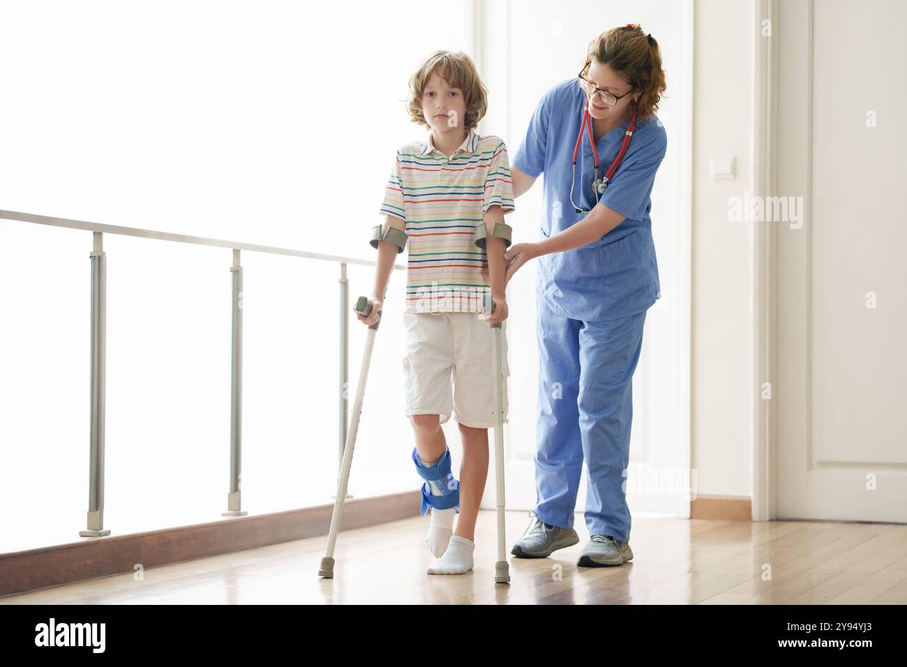 Injured child on crutches. Boy in cast on foot and leg. Little kid with ...