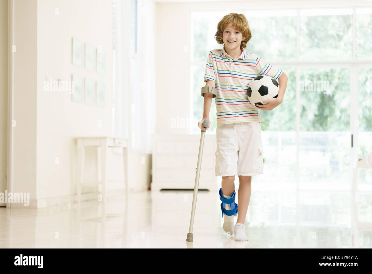 Injured child on crutches. Boy in cast on foot and leg. Little kid with ...