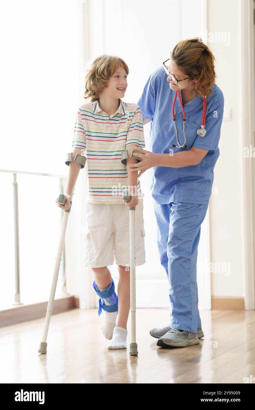 Injured child on crutches. Boy in cast on foot and leg. Little kid with ...