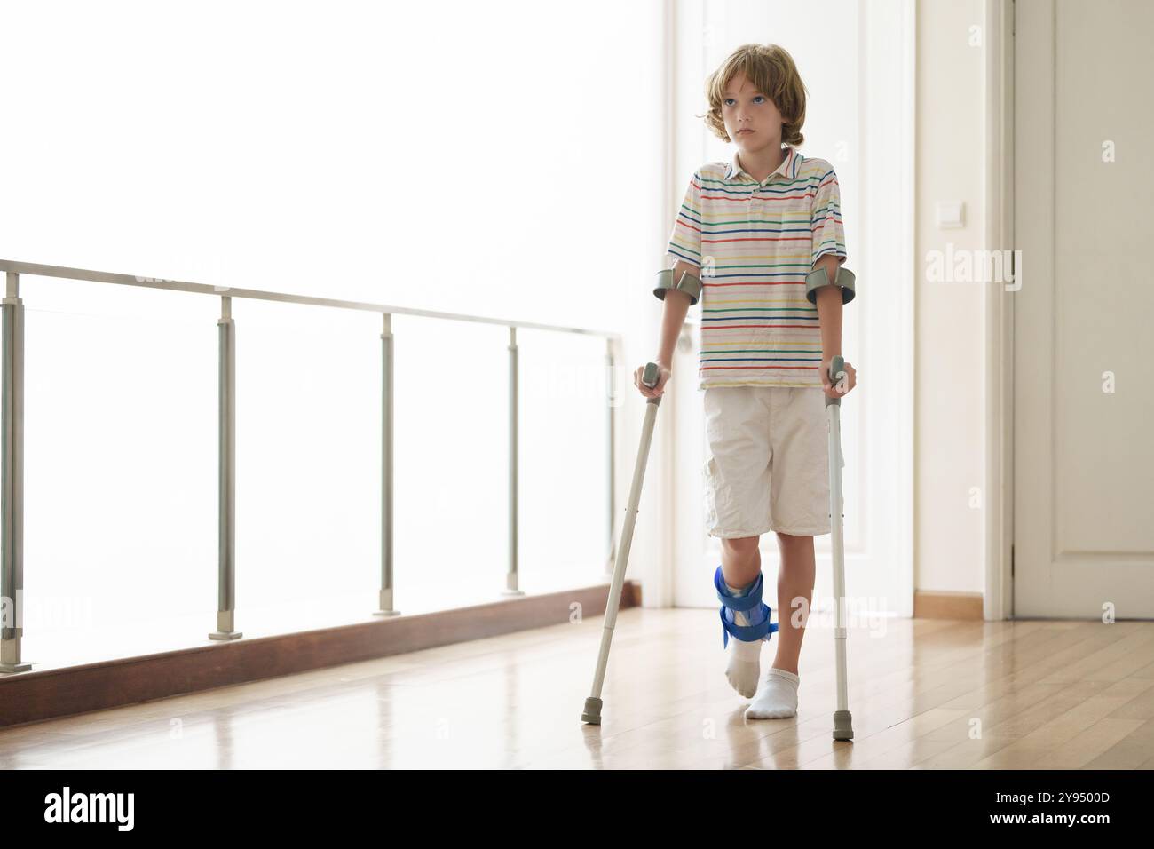 Injured child on crutches. Boy in cast on foot and leg. Little kid with ...