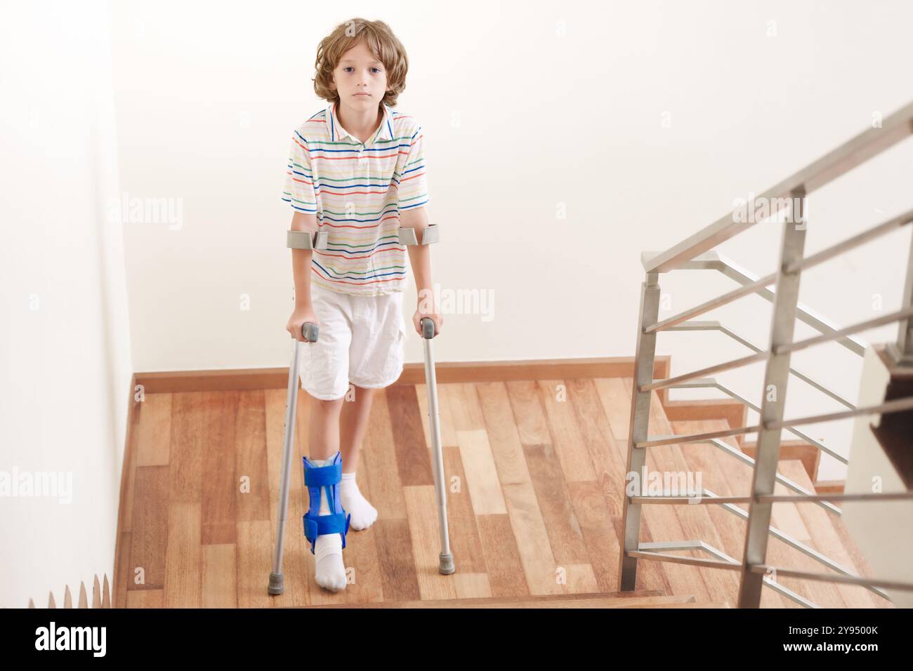Injured child on crutches. Boy in cast on foot and leg. Little kid with ...