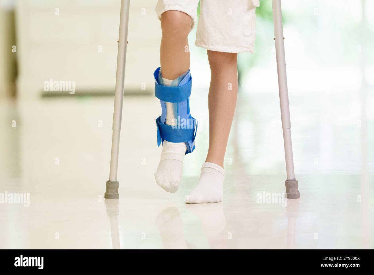 Injured child on crutches. Boy in cast on foot and leg. Little kid with ...
