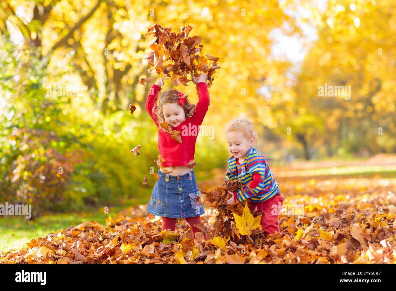 Happy children playing in beautiful autumn park on warm sunny fall day ...