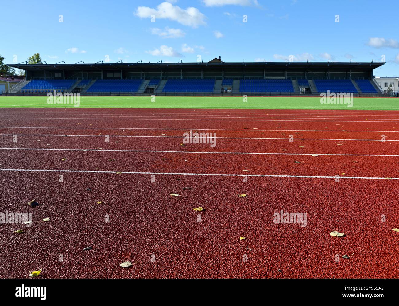 This image shows a close-up view of an athletics track, with bright red ...