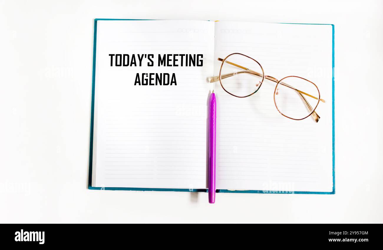 The text of today's meeting agenda is written on a notepad with glasses ...