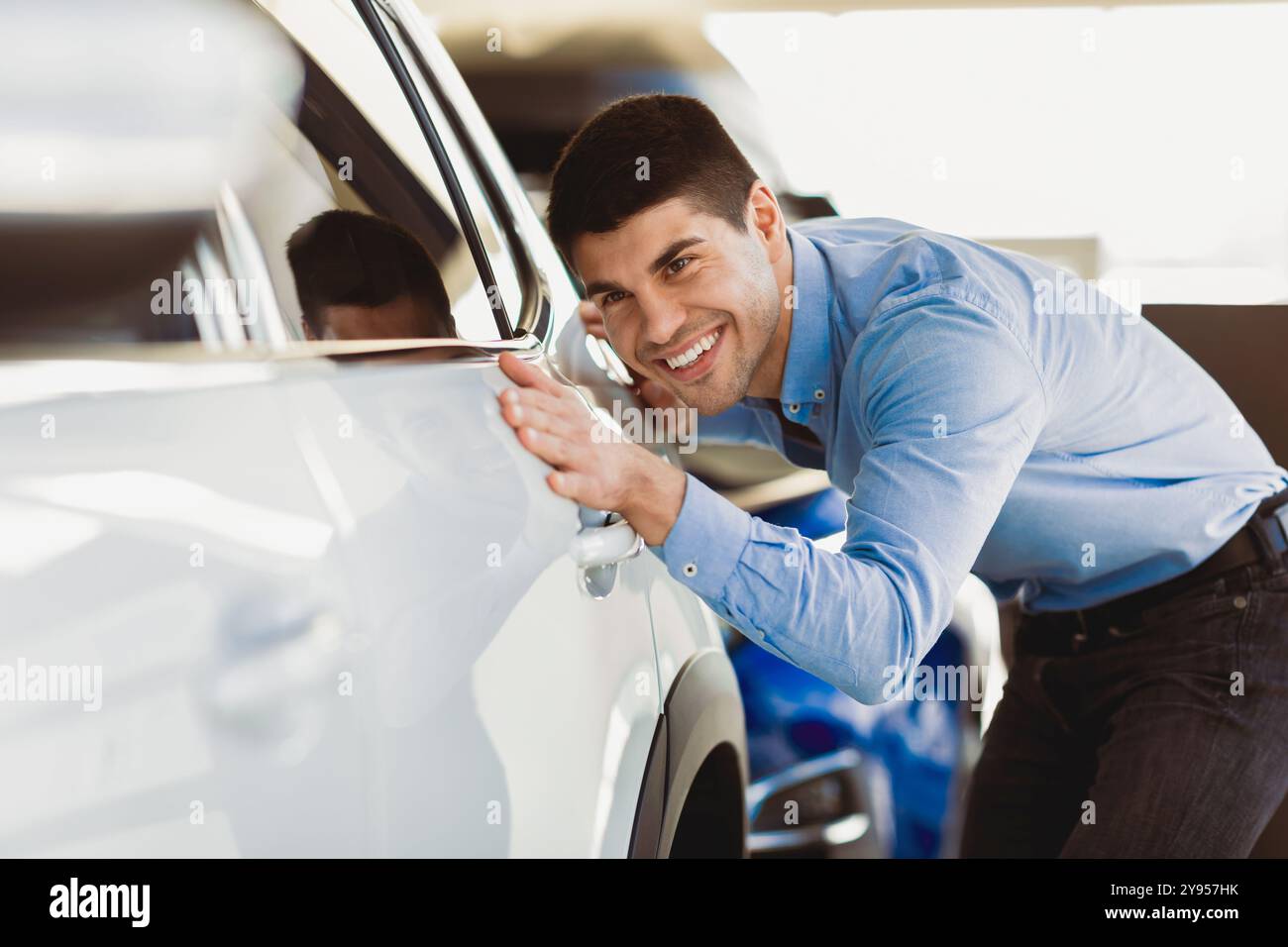 Happy Guy Touching His Auto In Dealership Showroom Stock Photo - Alamy