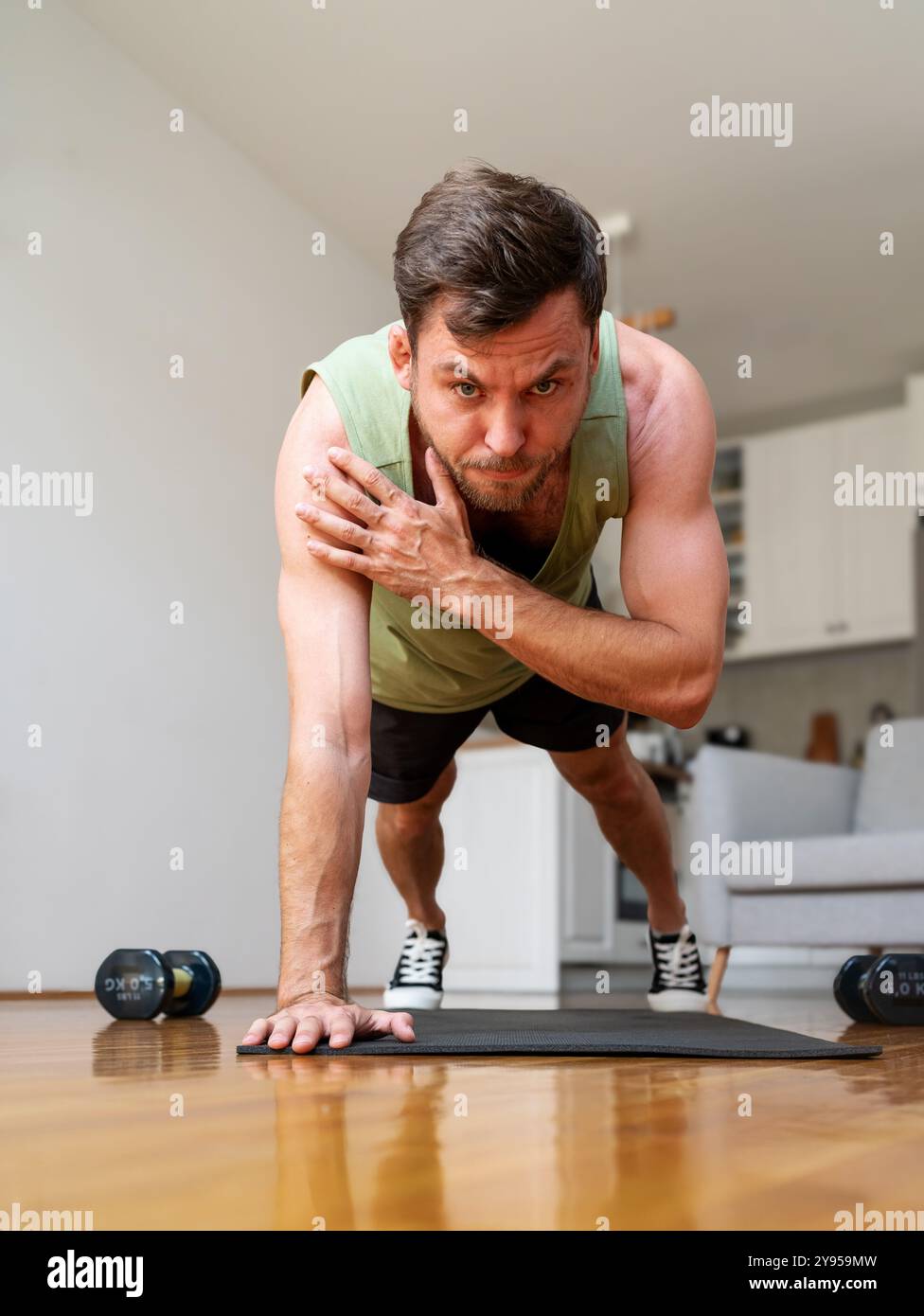 Man does arms curling exercise in plank position. Home workout Stock ...