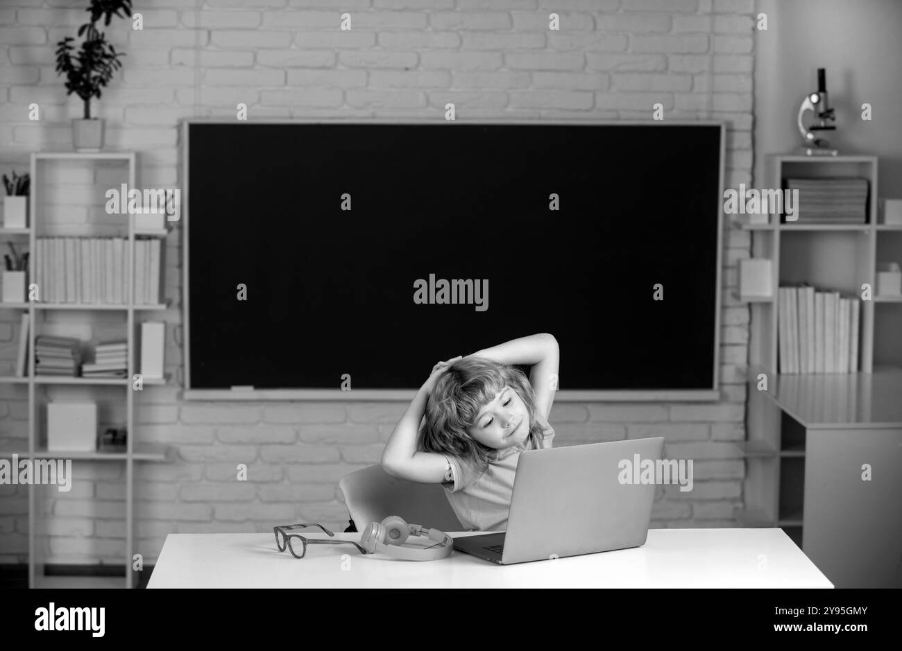 Cute little school kid boy study in a classroom. Portrait of pupil rest ...