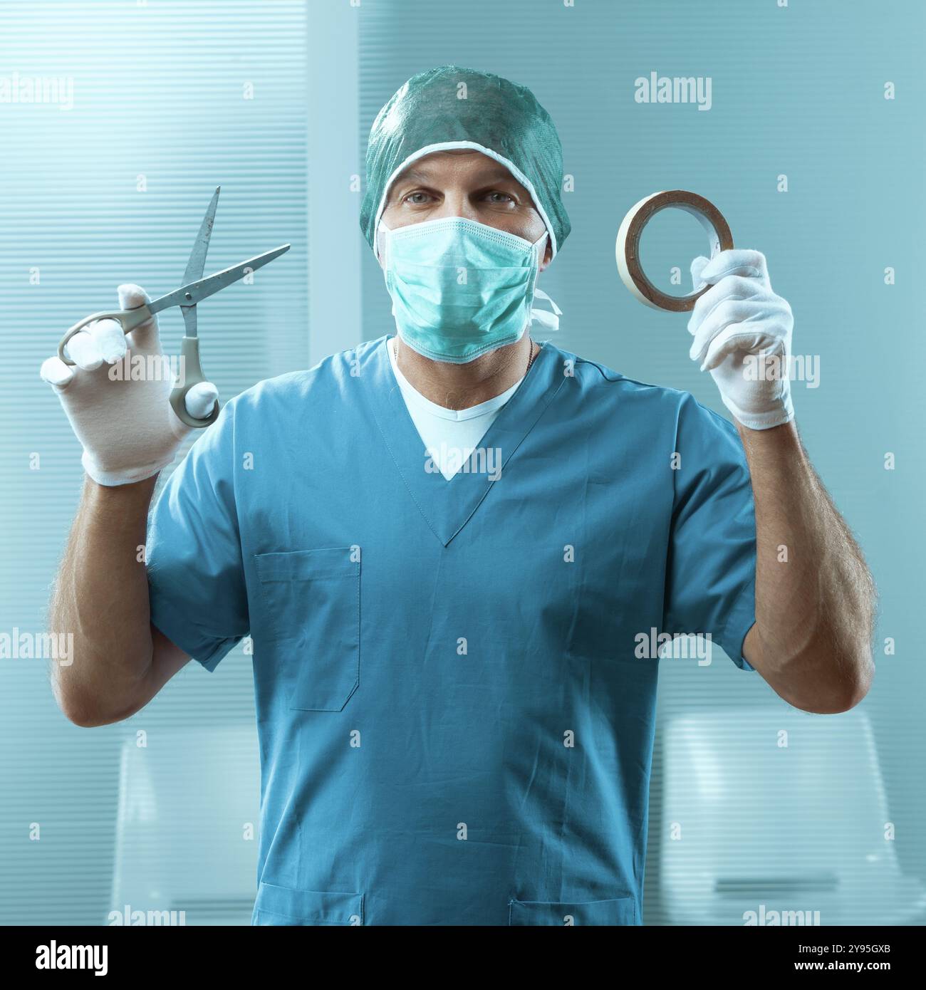 Male medical professional in surgical attire humorously brandishes ...
