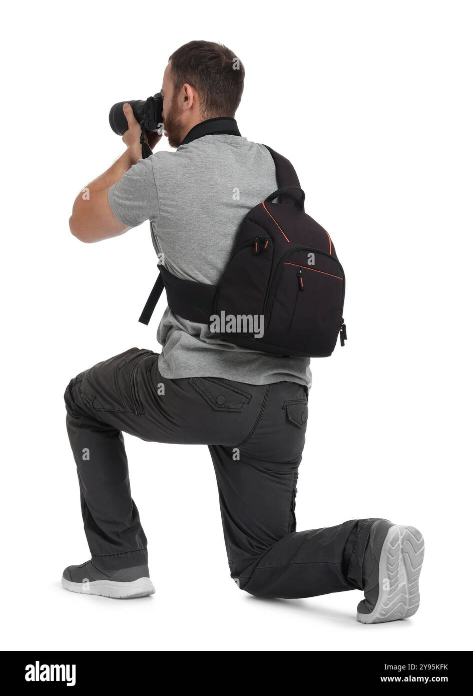 Photographer with backpack and camera taking picture on white ...
