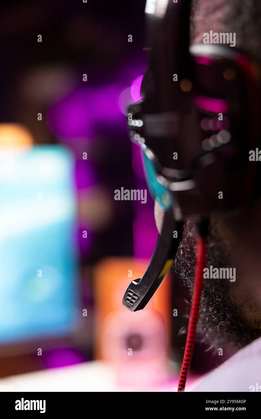 Pro gamer wearing headphones playing game, teaching audience ...