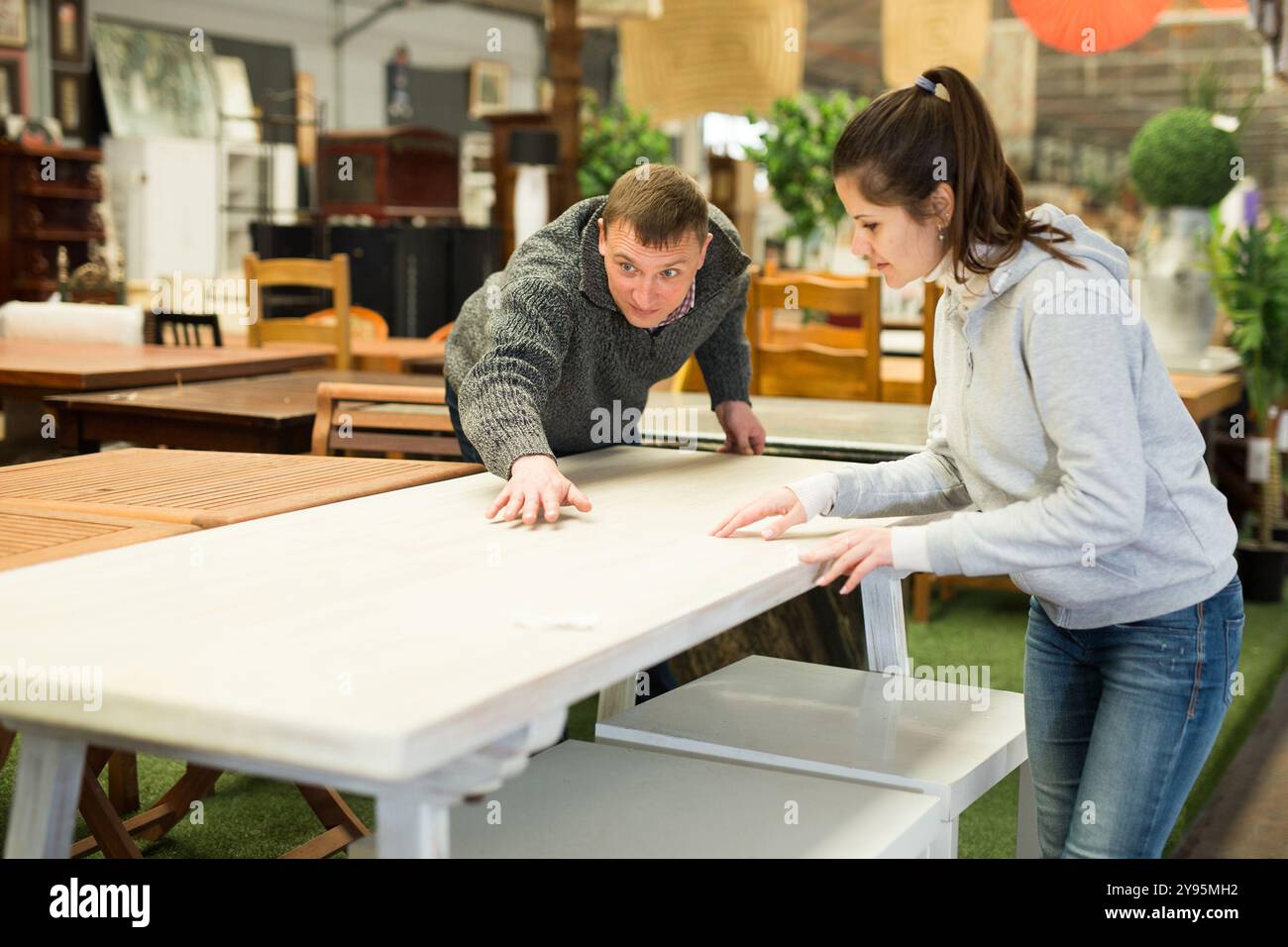 Woman and man consumer choosing table furniture store Stock Photo - Alamy