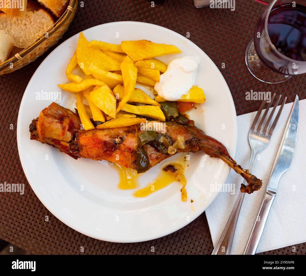 Baked rabbit leg with fried potatoes and spicy aioli Stock Photo - Alamy