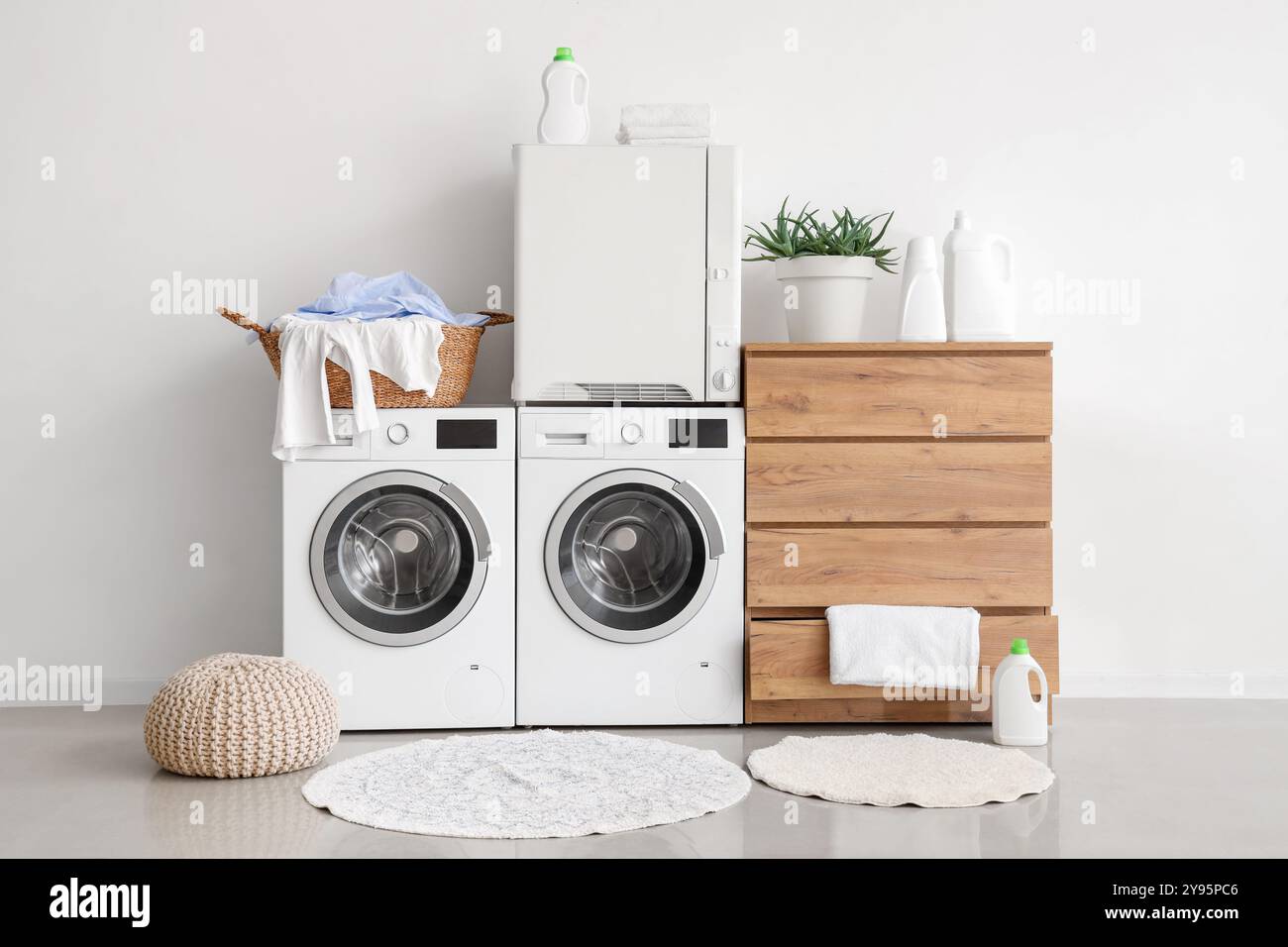 Washing machines, dryer, basket with clothes and chest of drawers in ...