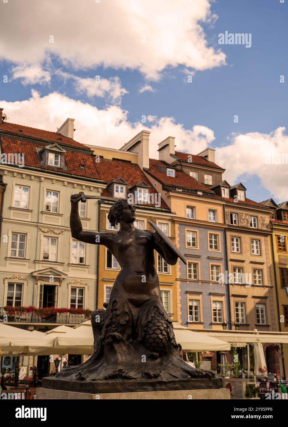 The iconic mermaid statue stands amidst colorful historic buildings in ...