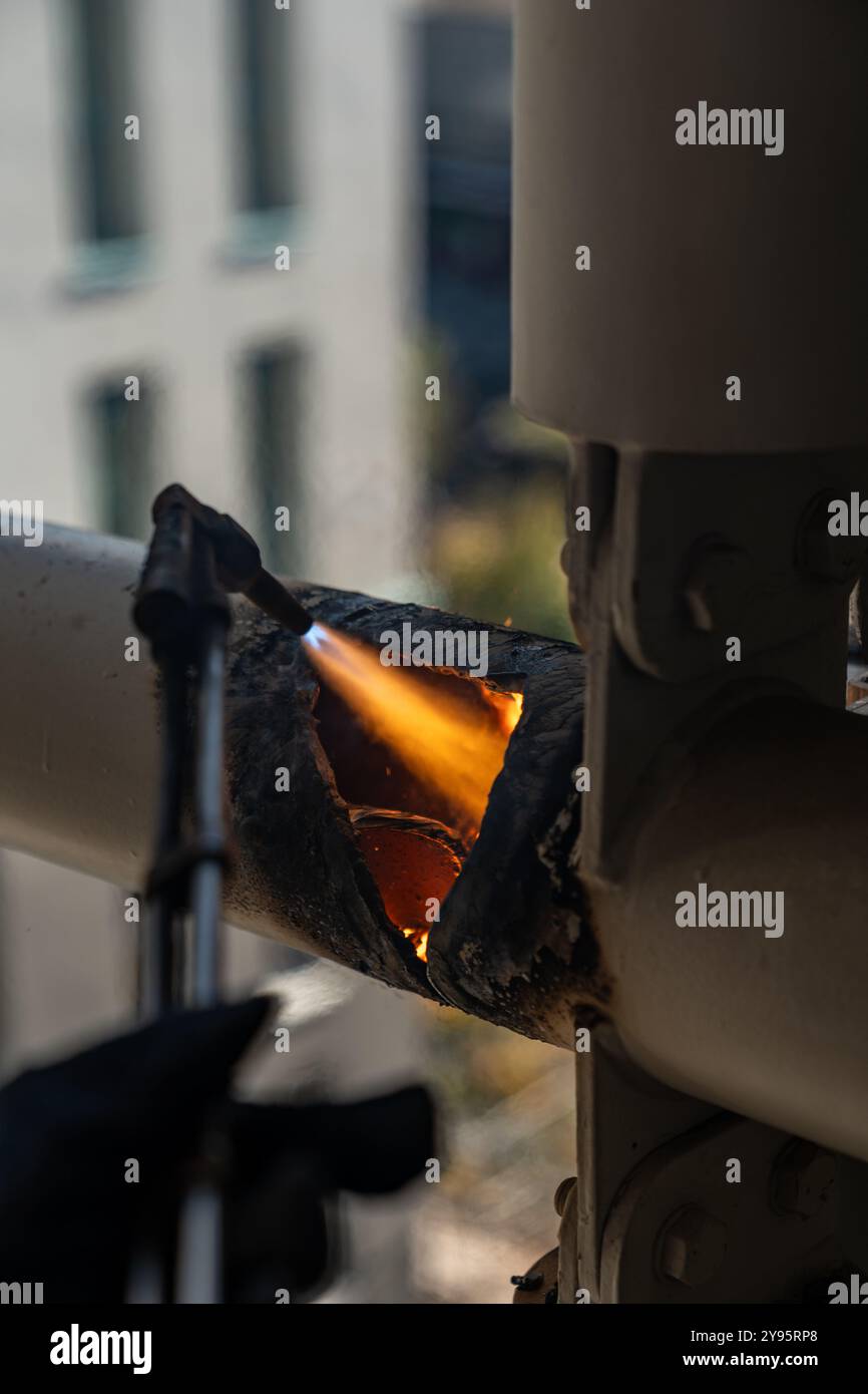 Construction worker is using a blowtorch to weld a steel structure on a ...