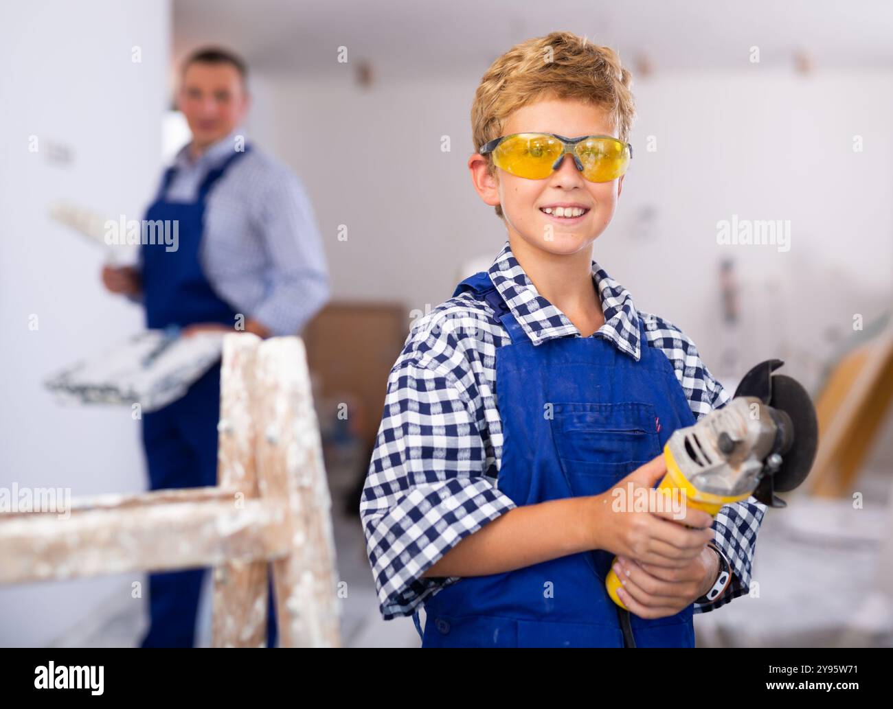 Portrait of positive young boy with angle grinder Stock Photo - Alamy