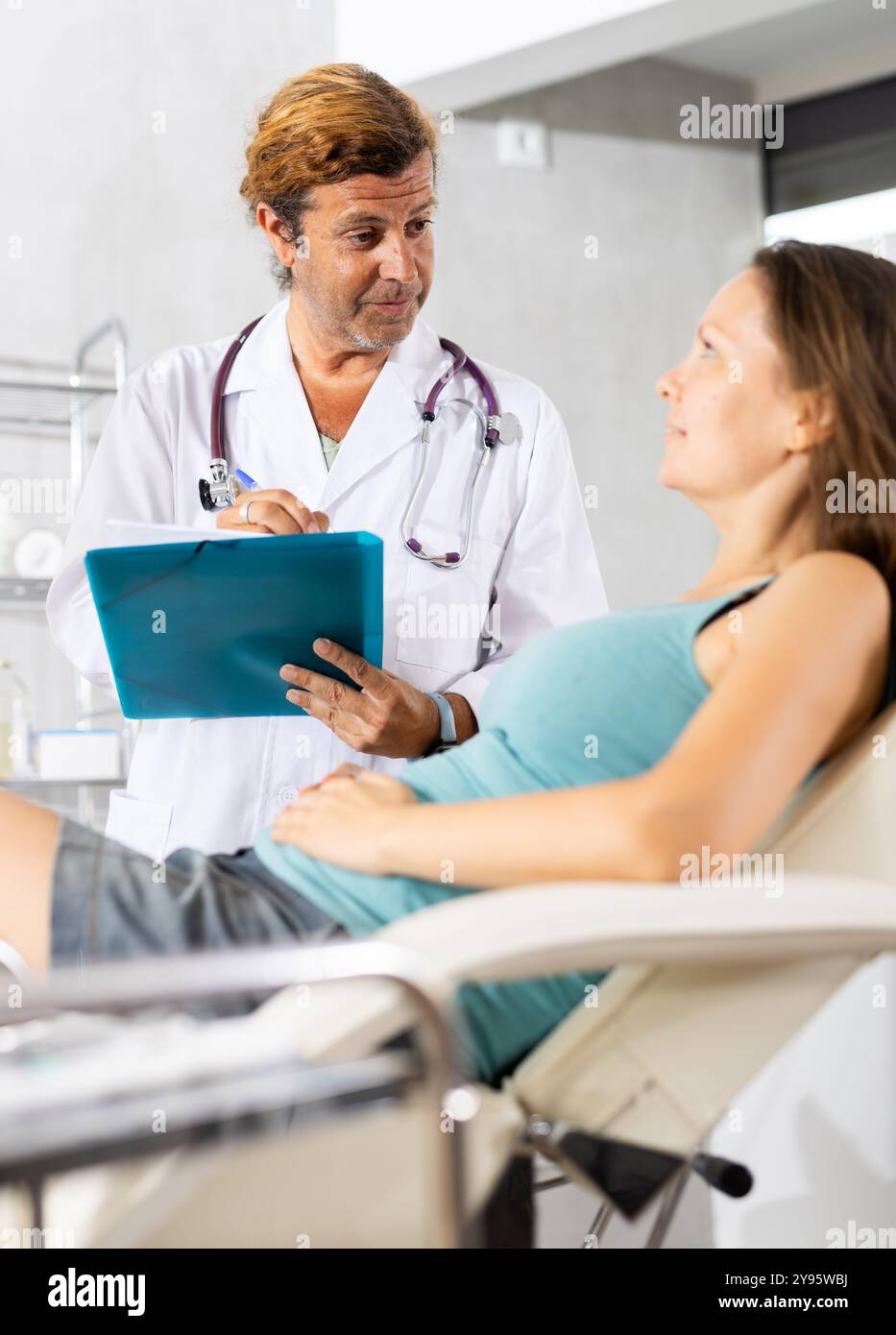 Positive doctor conducting questionnaire of female patient in medical ...