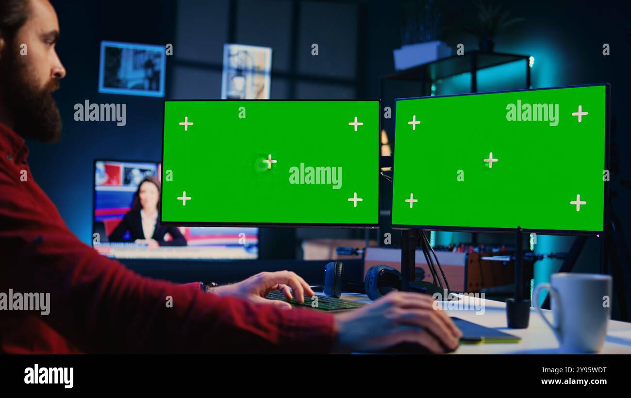 Photographer uses photo editing software on chroma key PC display in ...