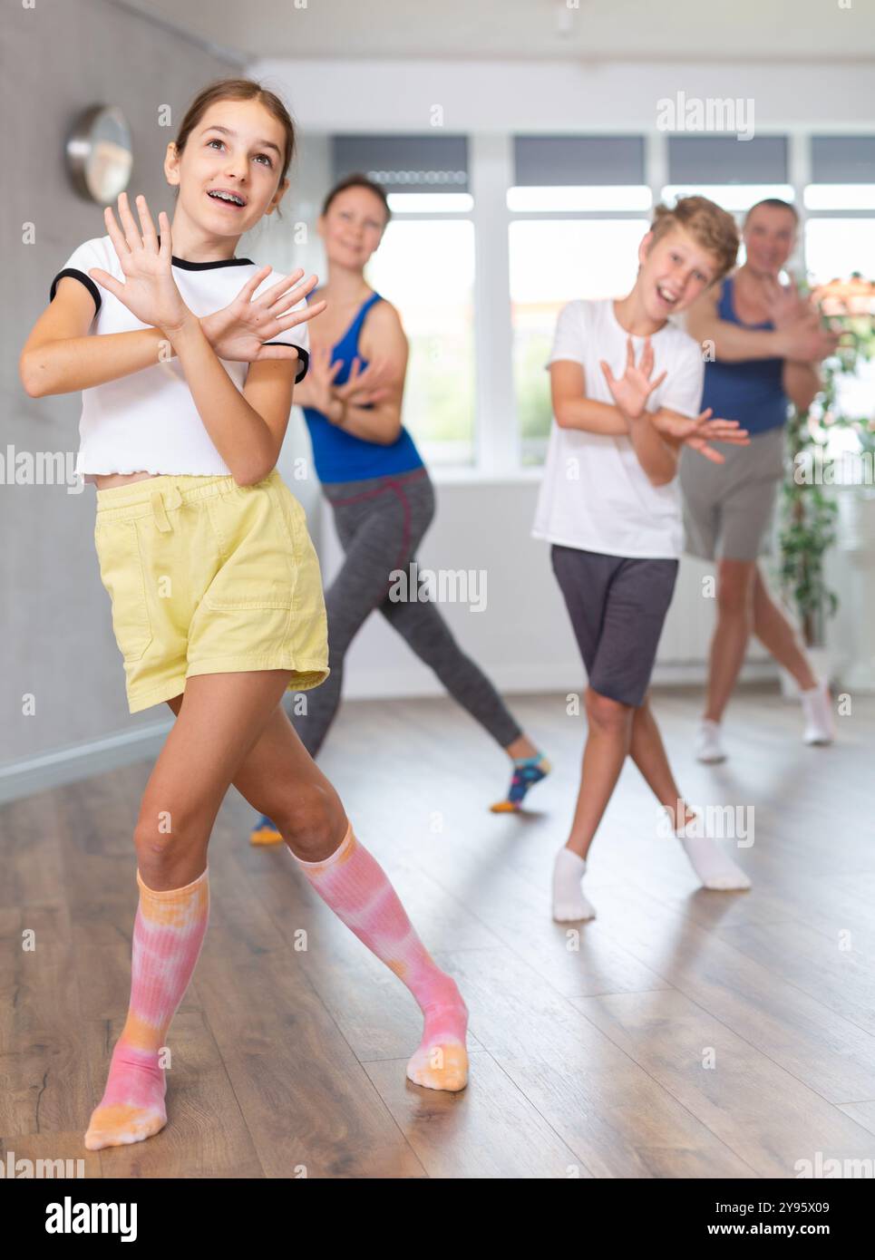 family learning dynamic boogie woogie in pair in dance studio during ...