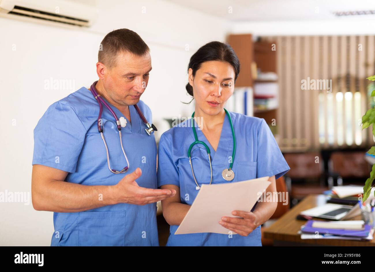 Two doctors checking patient papers in clinic Stock Photo - Alamy