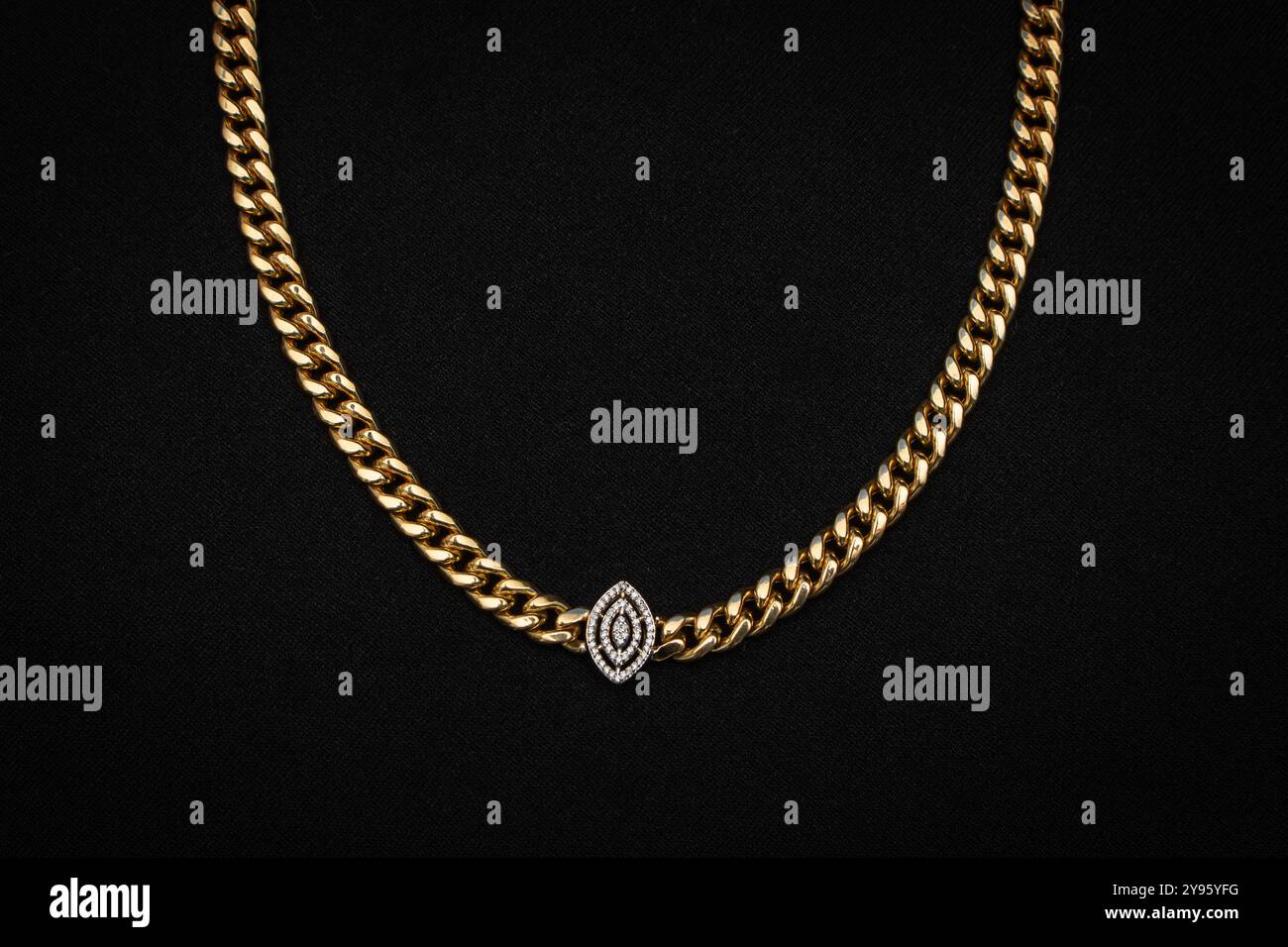 A classic gold chain necklace featuring a stunning eye-shaped diamond ...