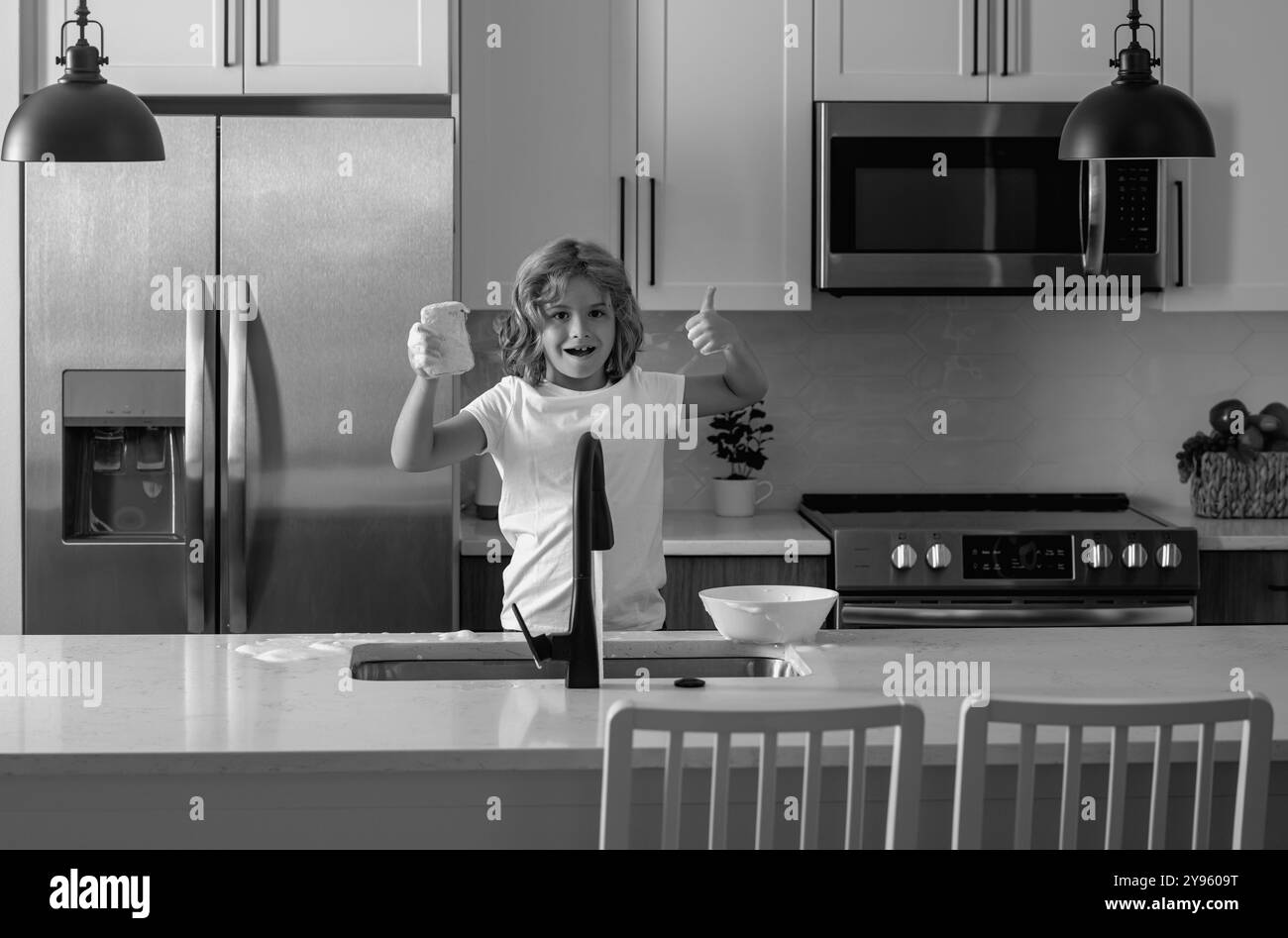 Funny twin boys helping in kitchen with washing dishes. Children having ...
