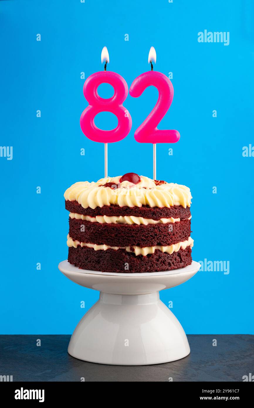 Red velvet birthday cake with number 82 candle Stock Photo - Alamy