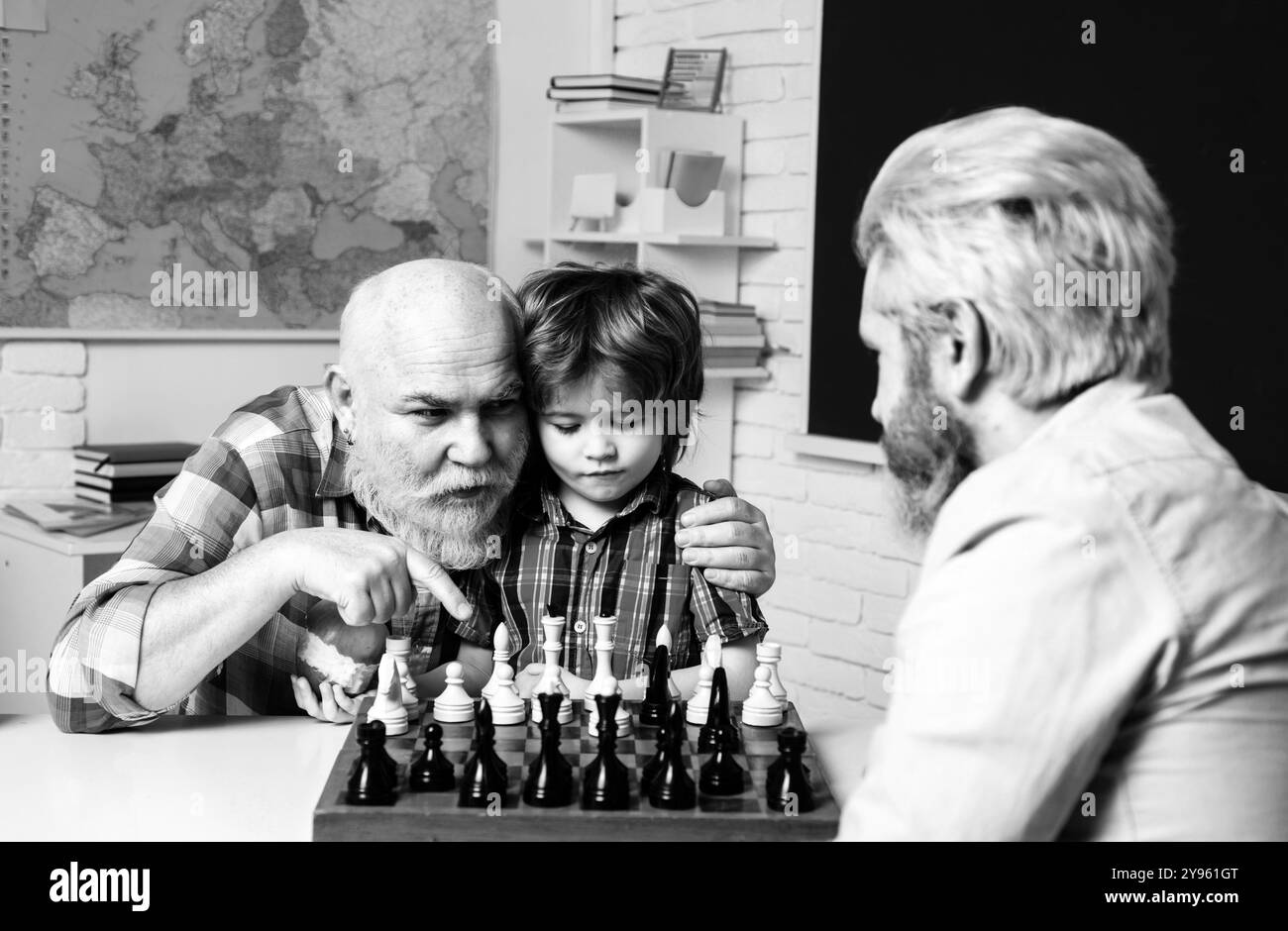 Grandfather father and son playing chess at home Stock Photo - Alamy