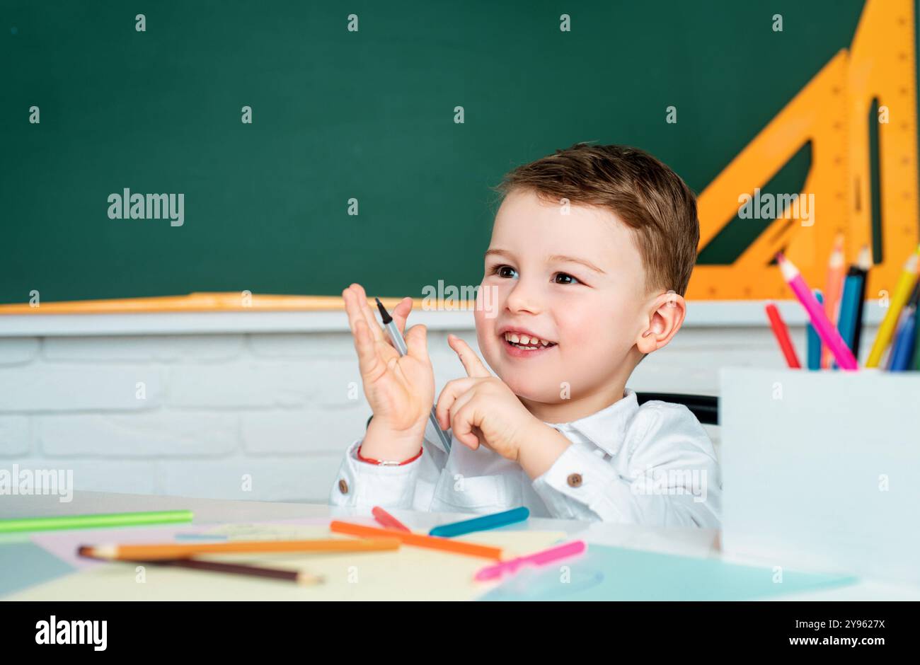 Happy Kid indoors of the class room with blackboard on a background ...