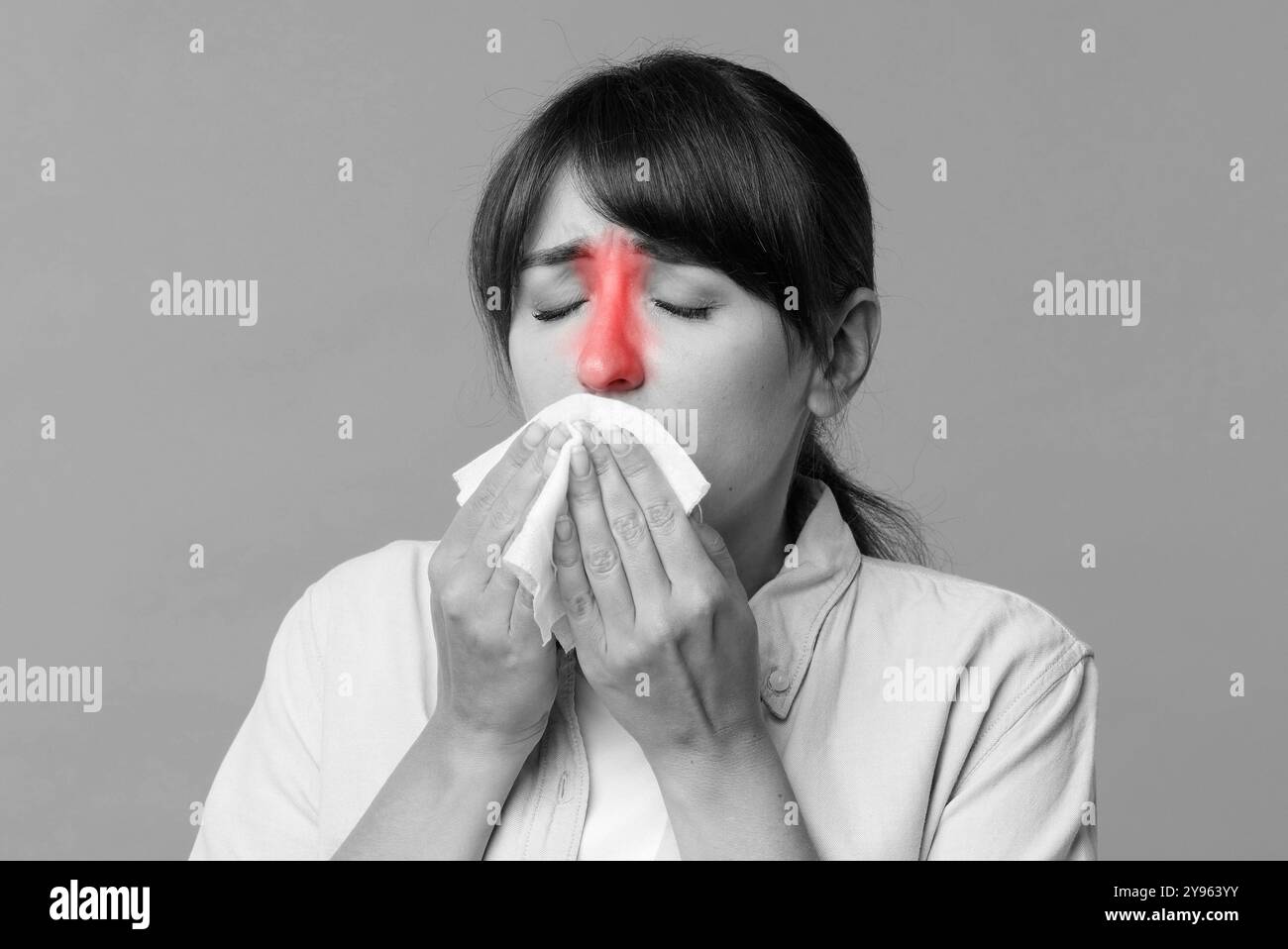 Woman with tissue suffering from sinusitis. Black and white effect with ...