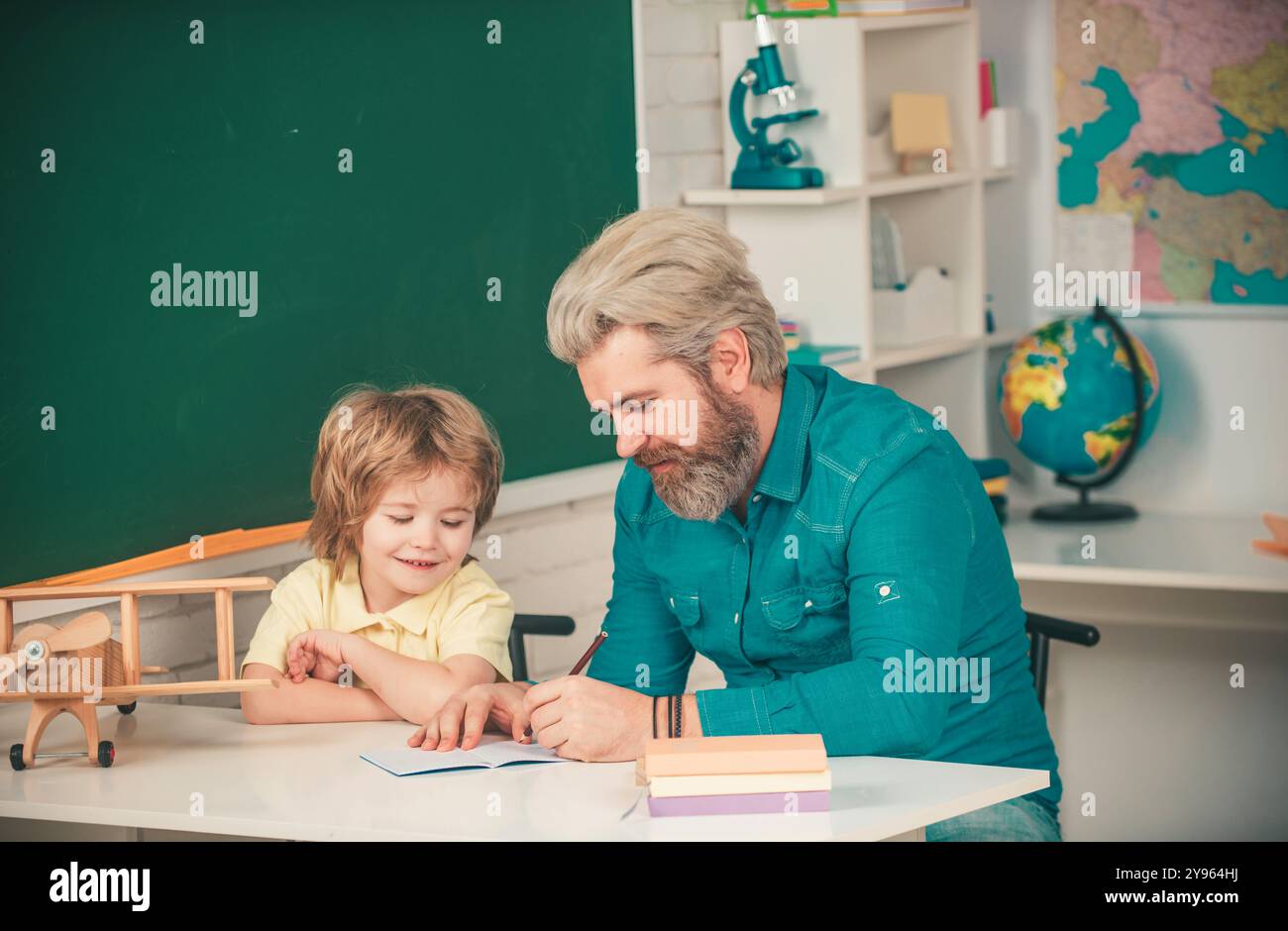 Teacher and pupil in classroom. Child home studying and home education ...