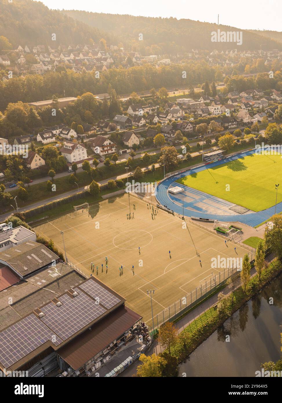 Overview of a football pitch in autumn atmosphere, surrounded by houses ...