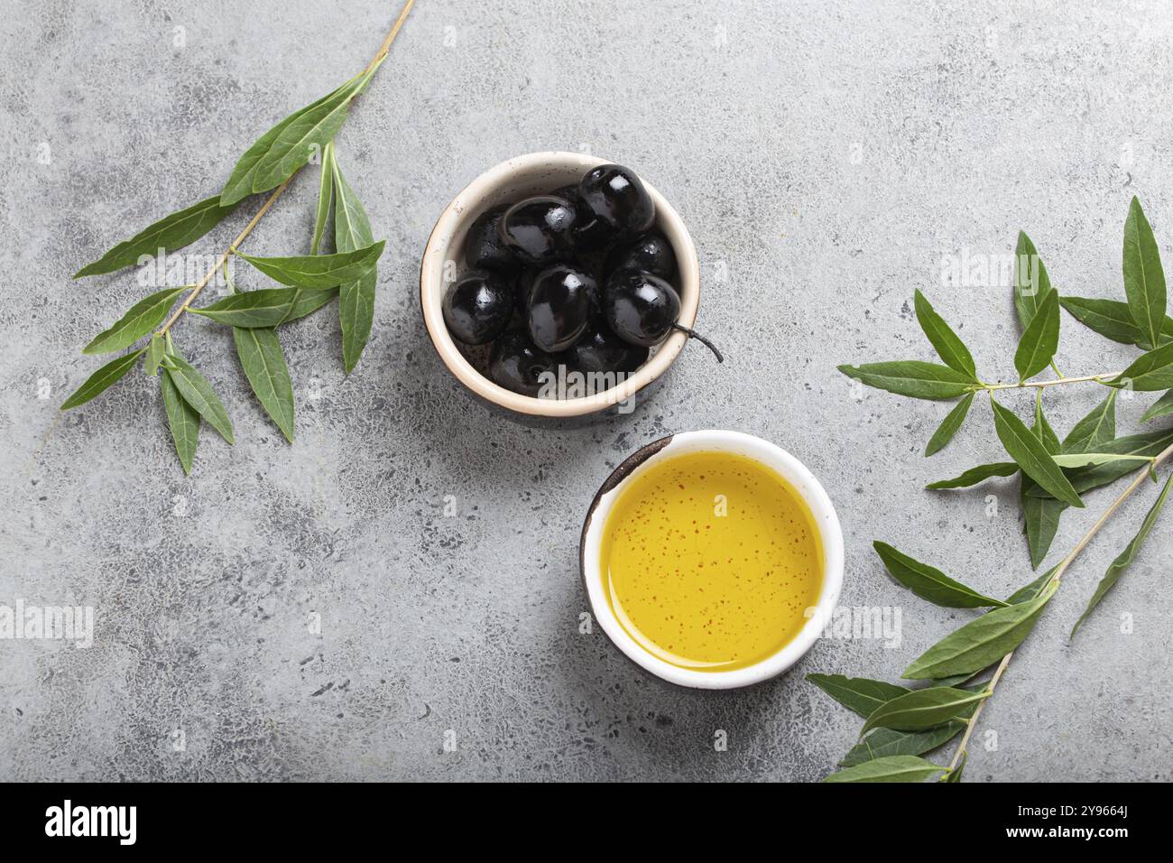 Black olives and extra virgin olive oil in little bowl with olive tree ...