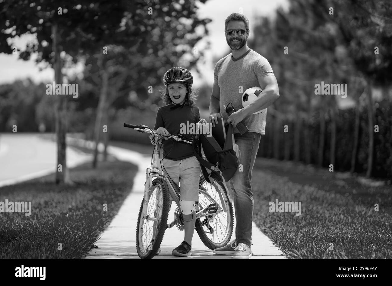 Father helping son get ready for school. Father teaching son riding ...