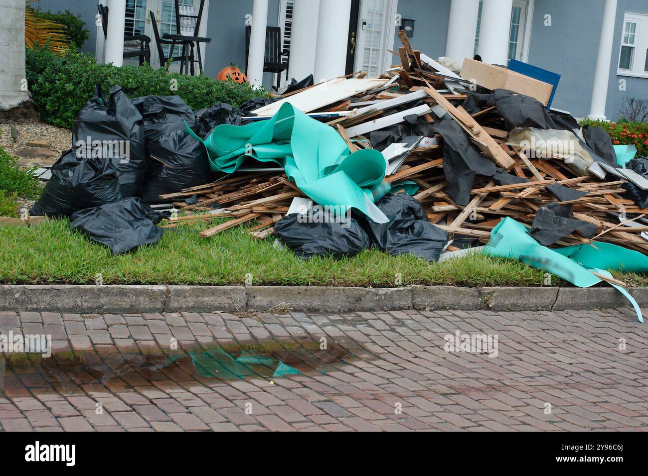 Large piles of trash, furniture, household items stacked on side of a ...