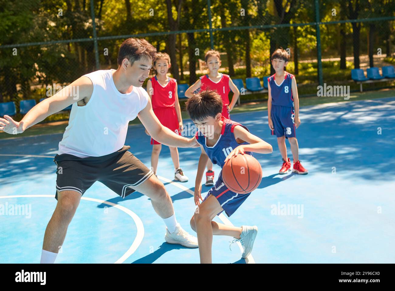 Coach Teaching Kids How To Play Basketball Stock Photo - Alamy