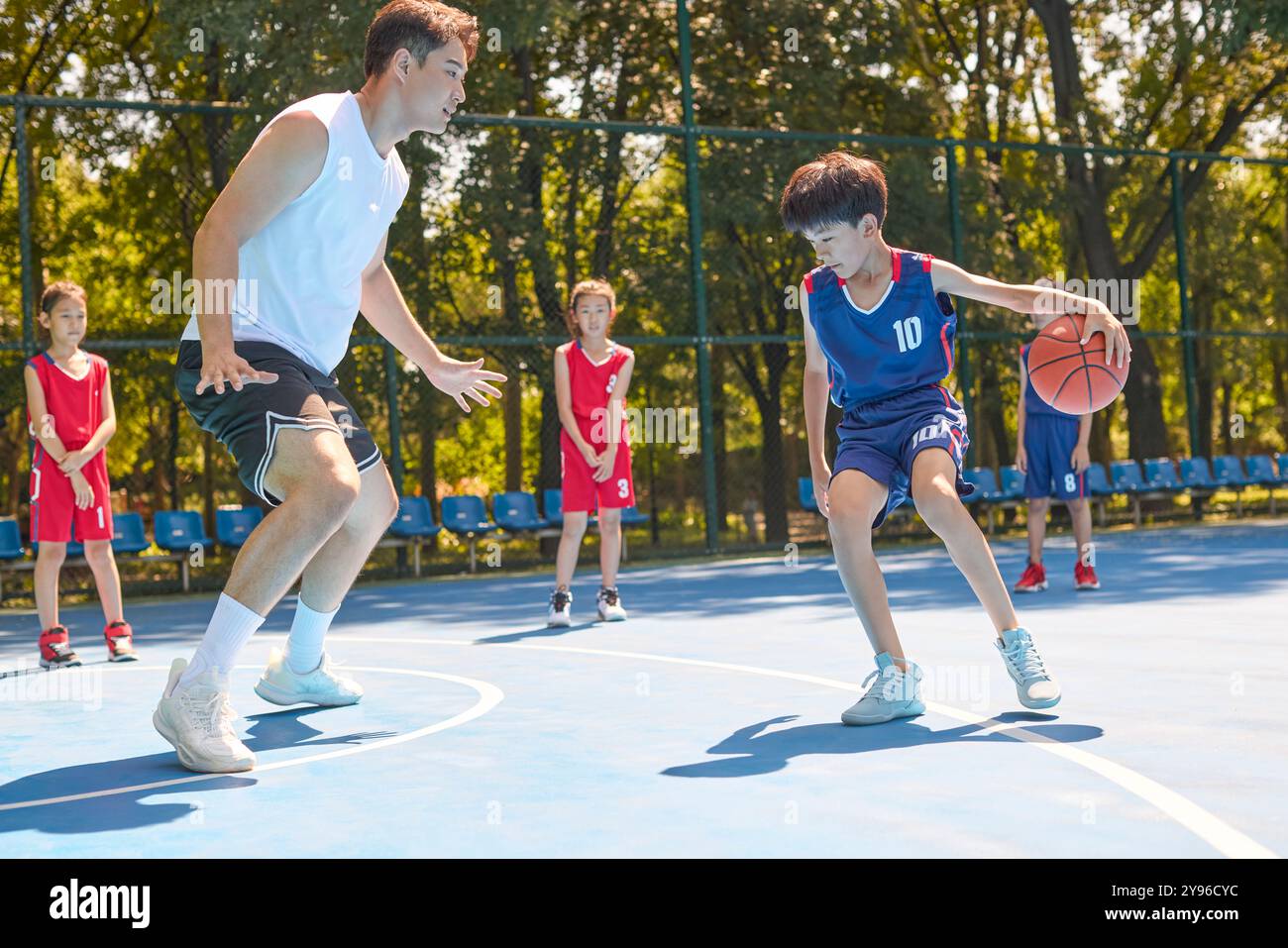 Coach Teaching Kids How To Play Basketball Stock Photo - Alamy
