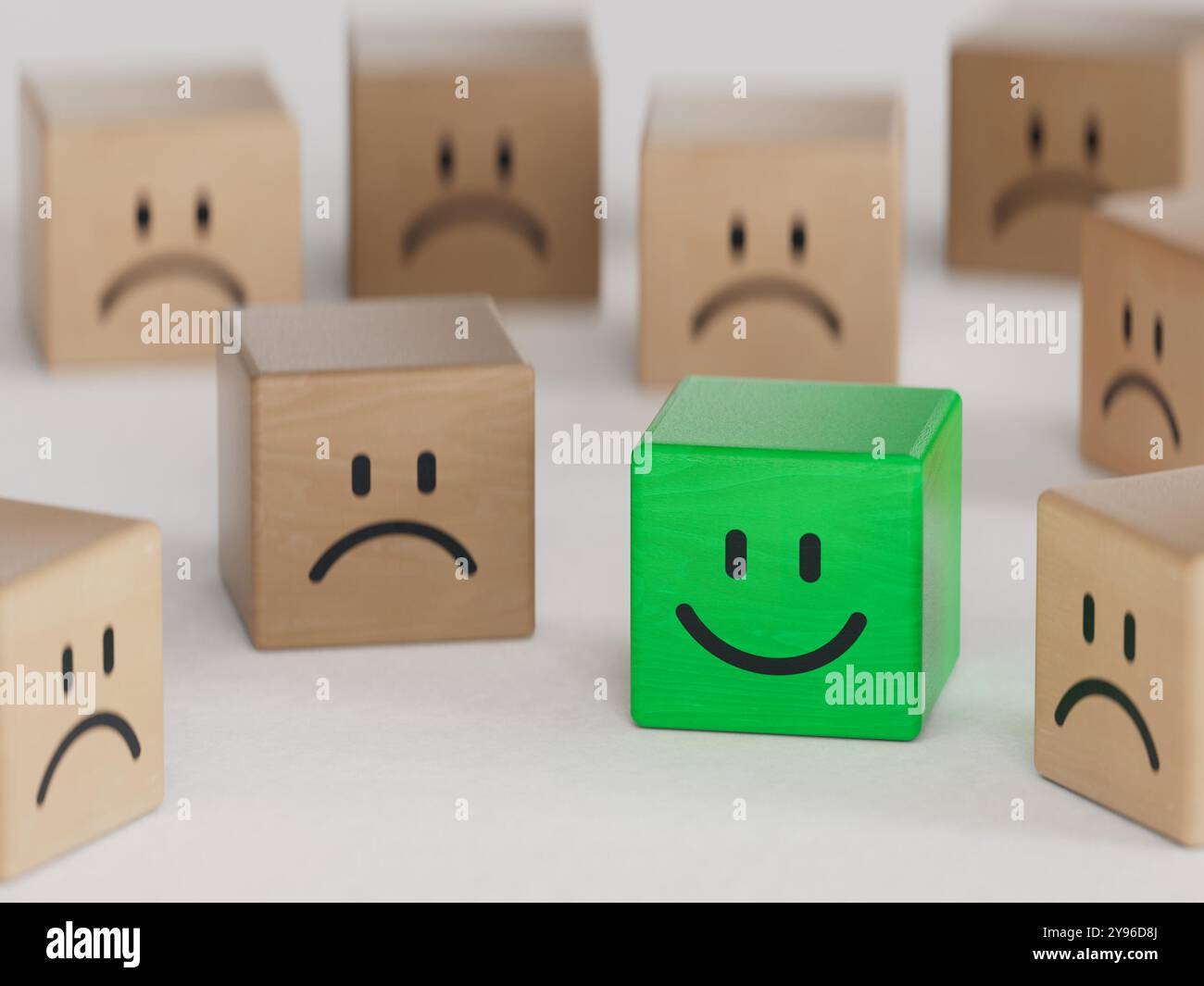 A GREEN sky with smiley face icon among sad face on wooden cubes over ...