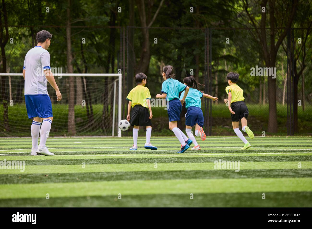 Chinese Kids Playing Football on Soccer Field Stock Photo - Alamy